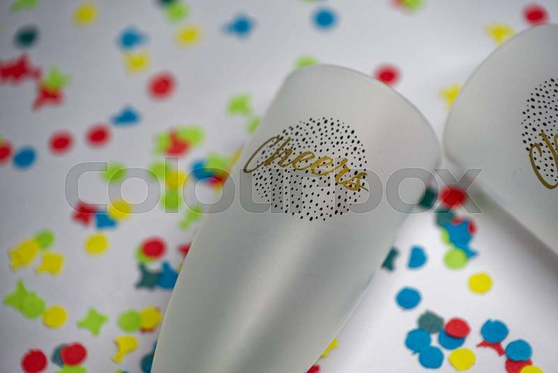 Cheers glass with colorful confetti for New Year 2026 and 20 | Colourbox